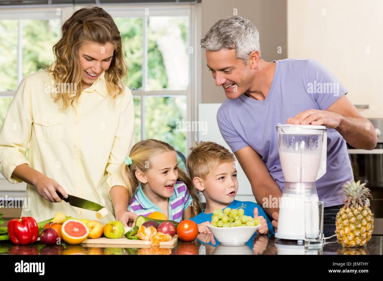 Happy family preparing healthy smoothie Stock Photo - Alamy