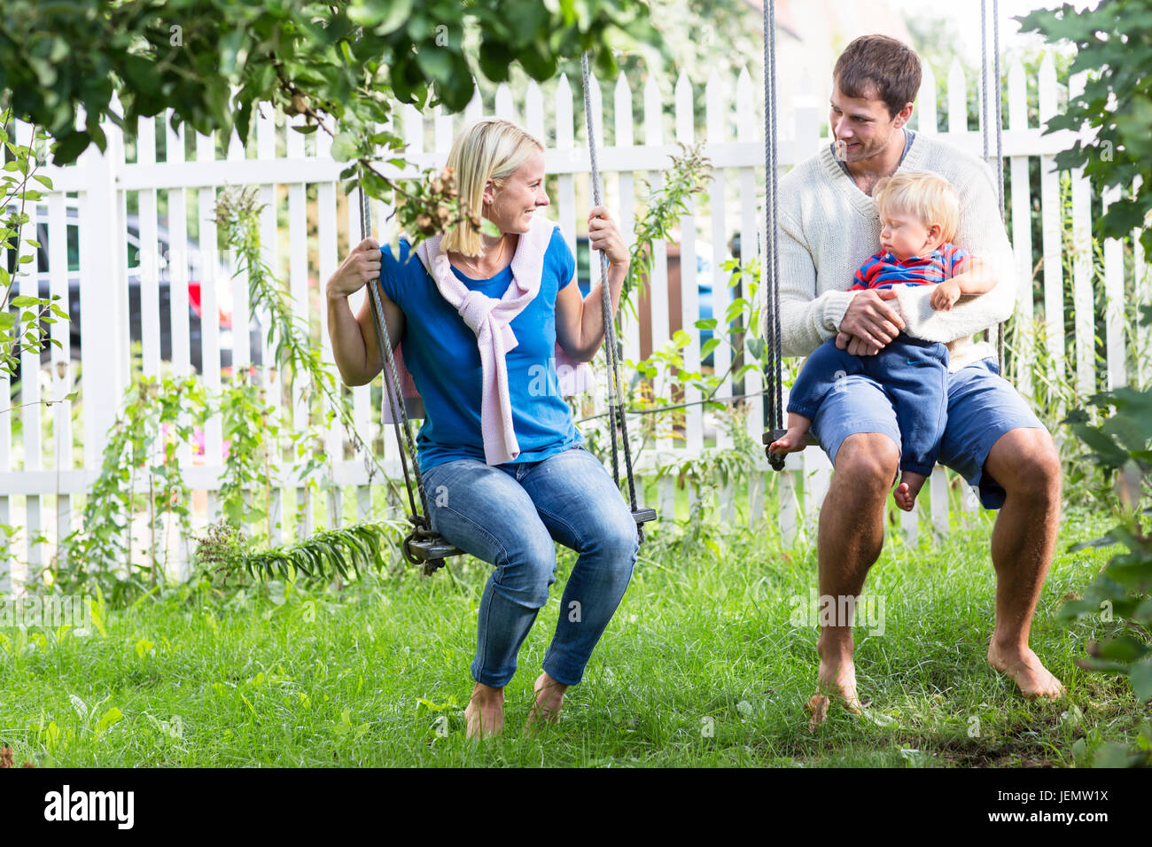 Parents with boy swinging Stock Photo - Alamy