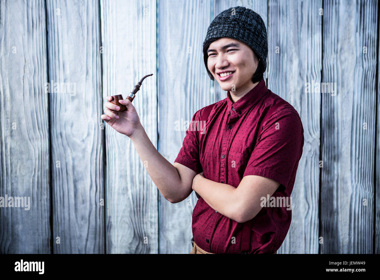 Smiling hipster smoking pipe Stock Photo - Alamy