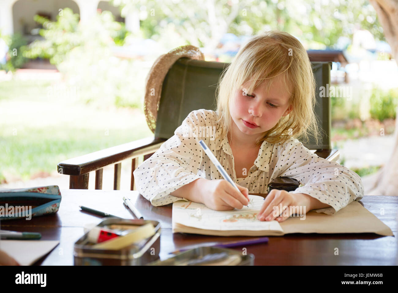 Girl writing in garden Stock Photo - Alamy