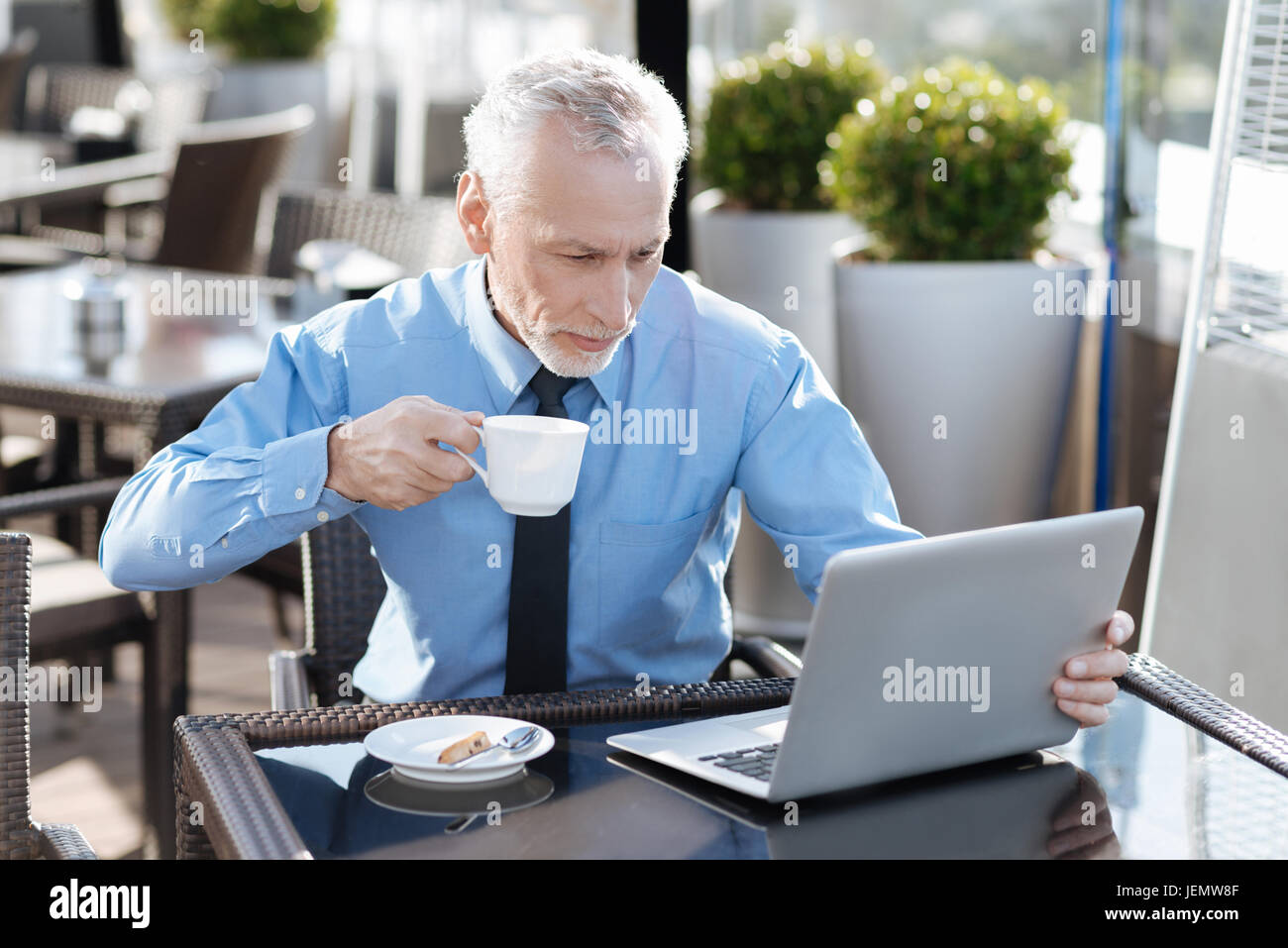 Concentrated office worker drinking coffee Stock Photo - Alamy