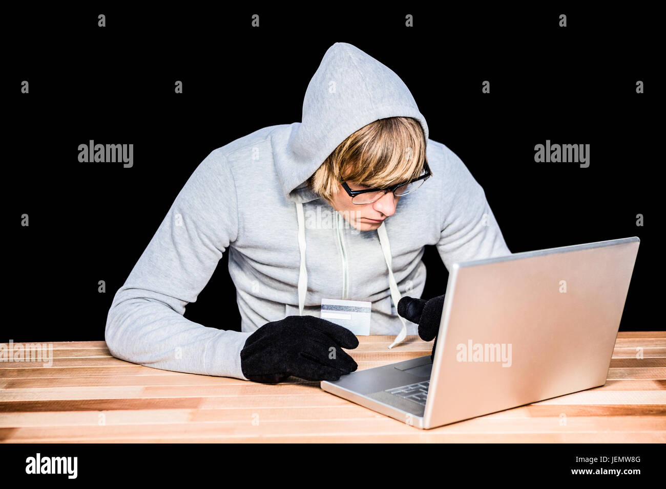Man in hood jacket hacking a laptop Stock Photo - Alamy