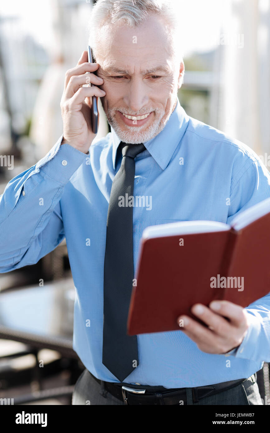 Portrait of delighted man while checking his timetable Stock Photo - Alamy