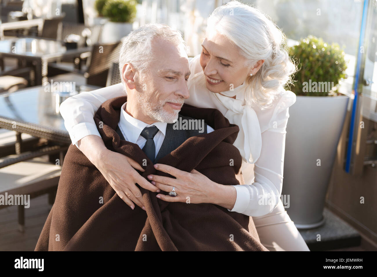 Tender woman covering her partner with plaid Stock Photo - Alamy