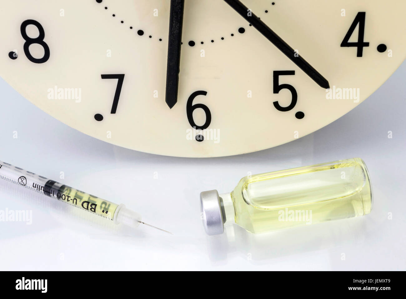 medicine vials and syringe, the clock shows the time of the medication ...