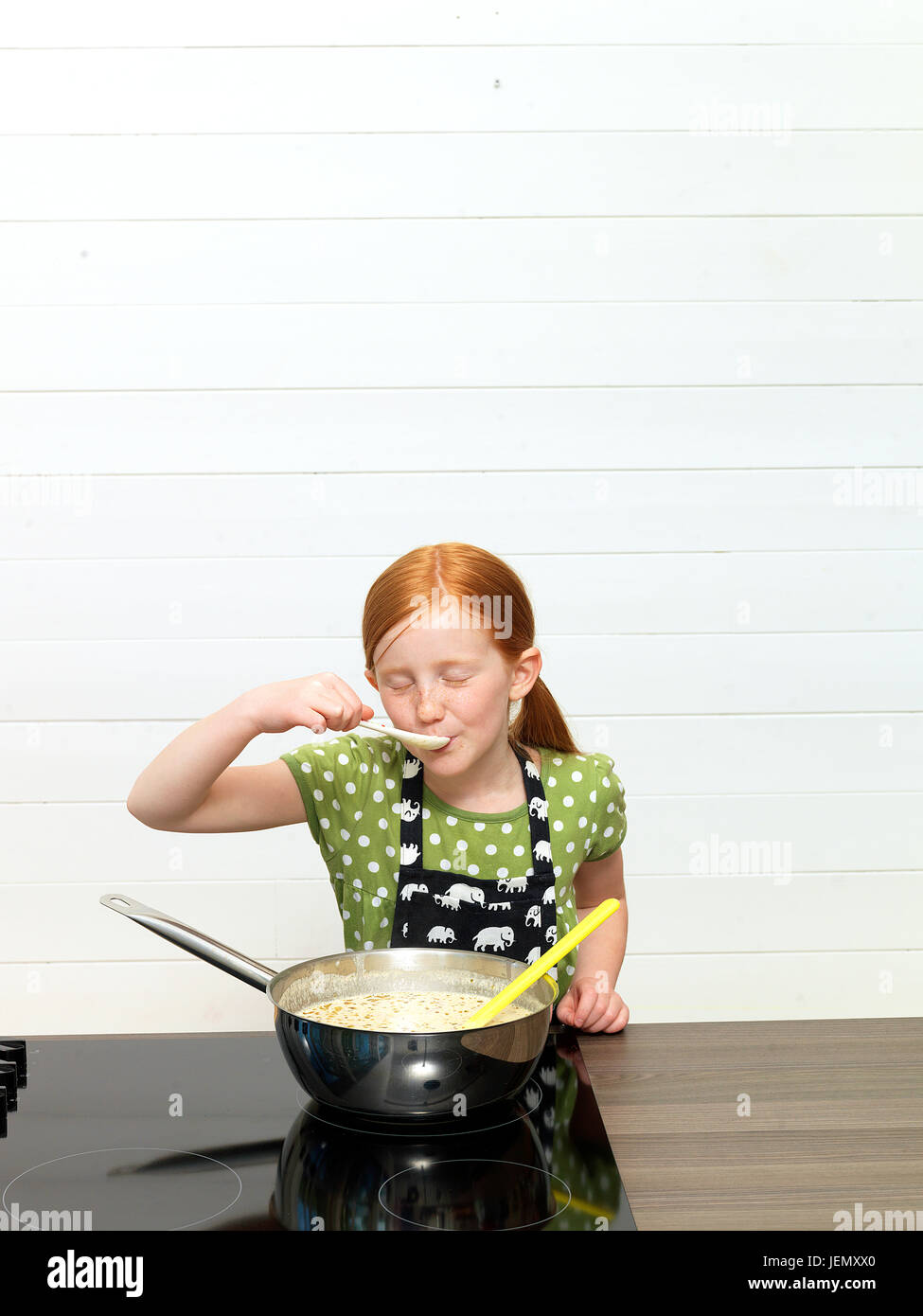 Girl tasting food Stock Photo - Alamy