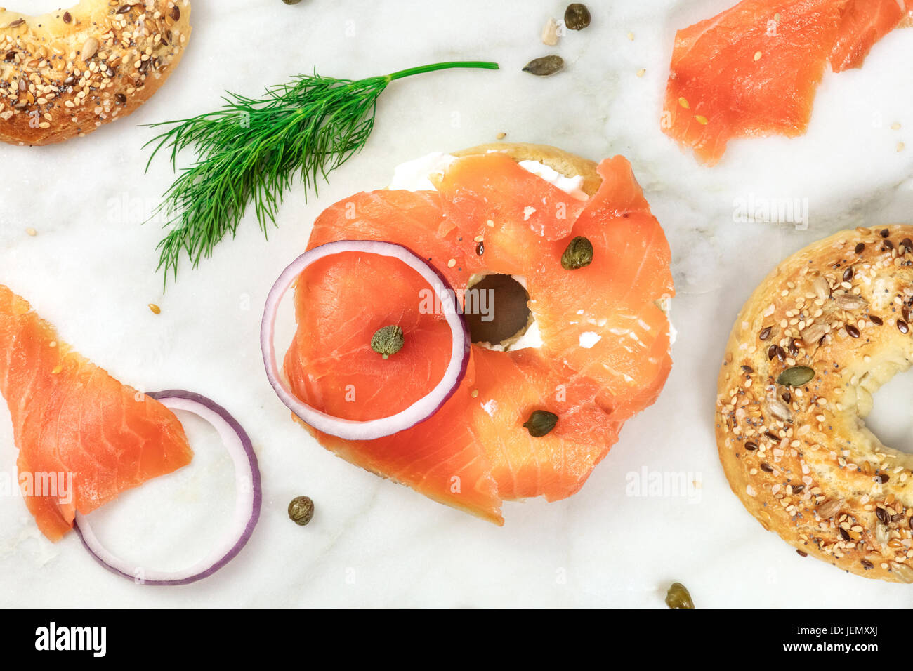 Making lox bagels, overhead photo on white marble background Stock ...