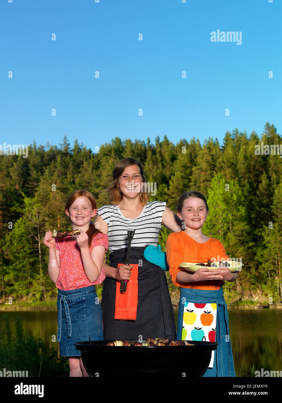 Mother with daughters having barbecue Stock Photo - Alamy
