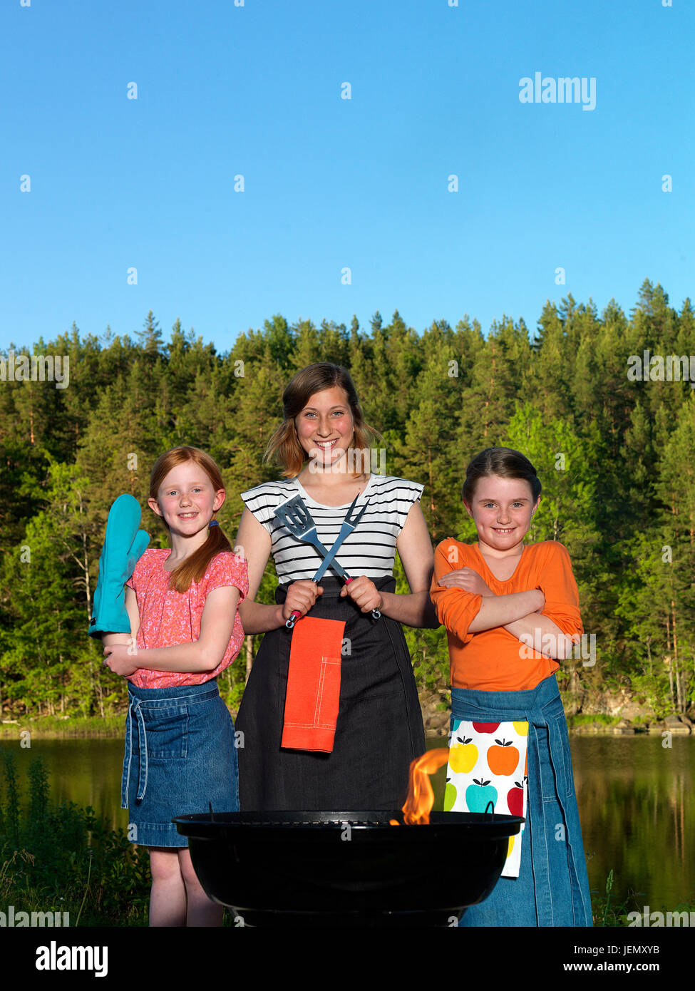 Mother with daughters having barbecue Stock Photo - Alamy