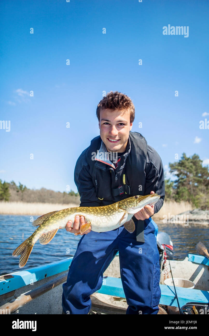 Young man holding caught fish Stock Photo - Alamy