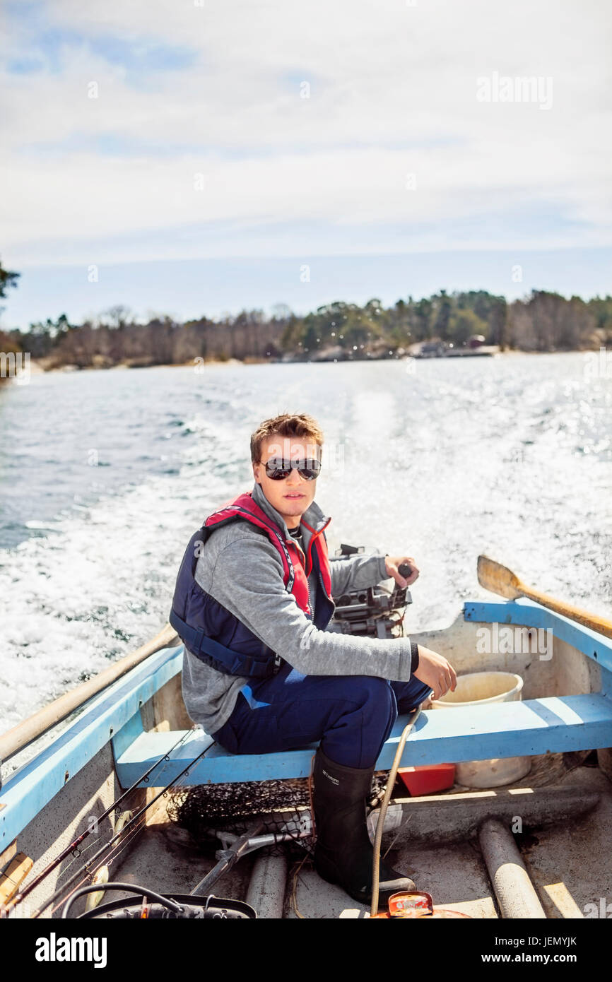 Young man sitting on motorboat hi-res stock photography and images - Alamy