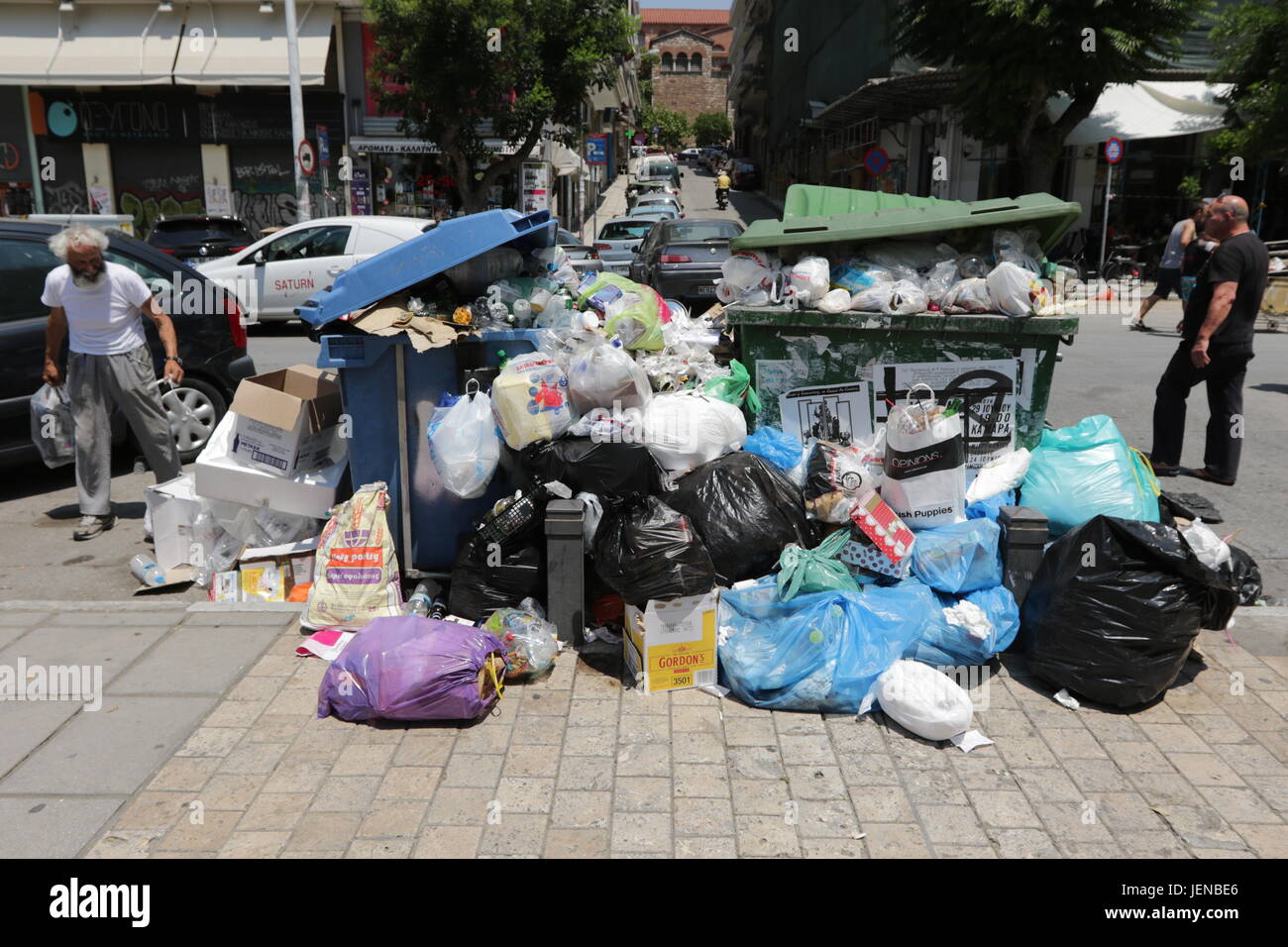 Thessaloniki, Greece. June 27th, 2017. People walk pass piles of litter ...
