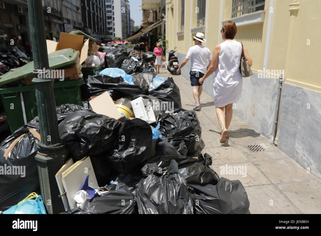 Thessaloniki, Greece. June 27th, 2017. People walk pass piles of litter ...