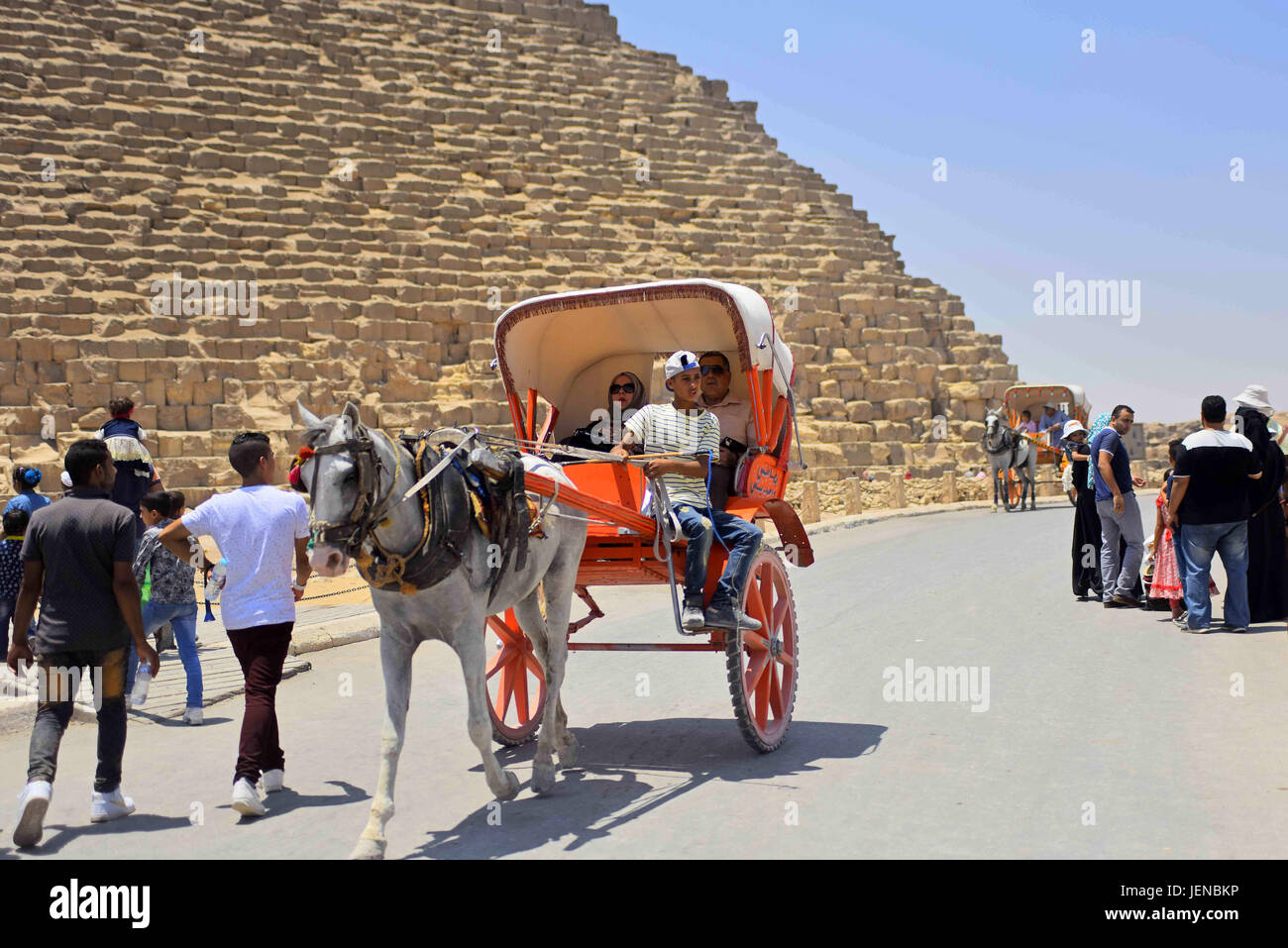 Cairo, Egypt. 27th June, 2017. Egyptians ride horse carts in front of the Giza pyramids, on the ...