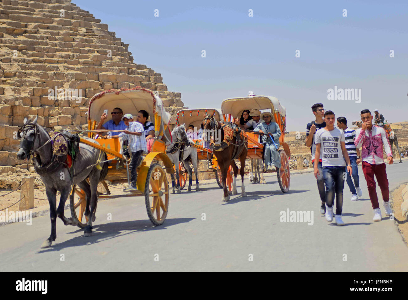 Cairo, Egypt. 27th June, 2017. Egyptians ride horse carts in front of the Giza pyramids, on the ...