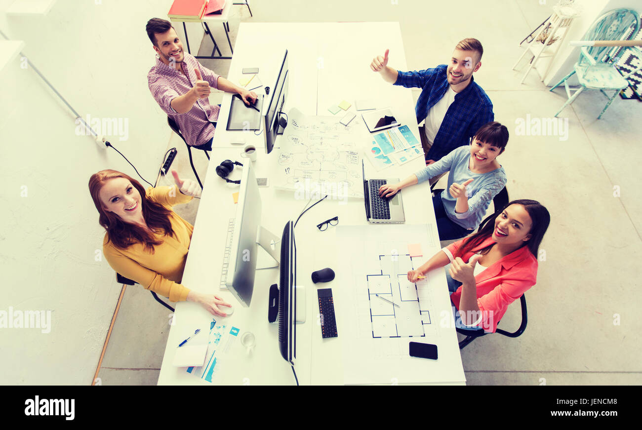 creative team with computers showing thumbs up Stock Photo - Alamy