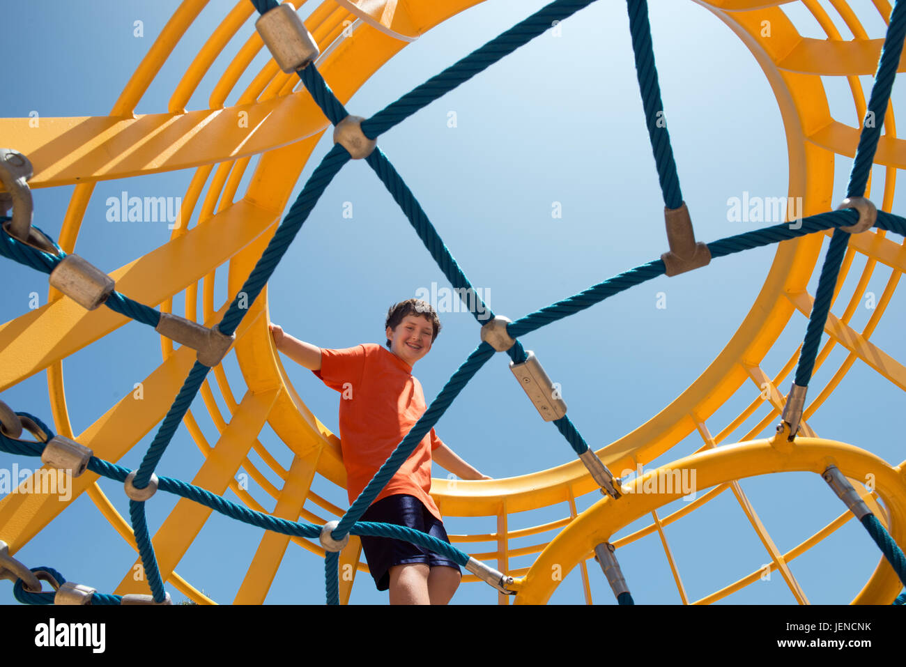 Boy playing on a jungle gym in a playground Stock Photo - Alamy