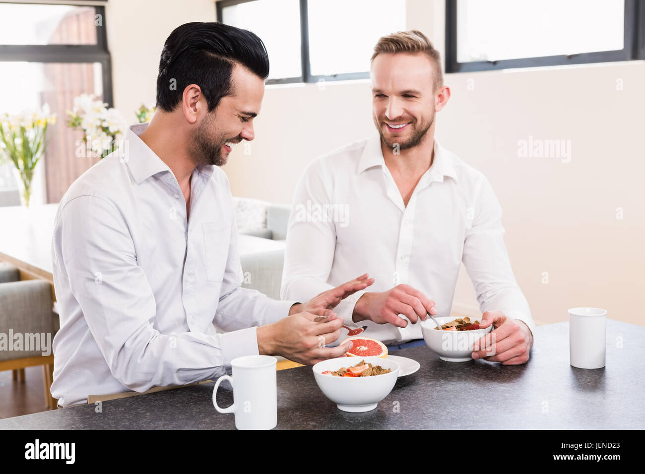 Smiling gay couple having breakfast Stock Photo - Alamy