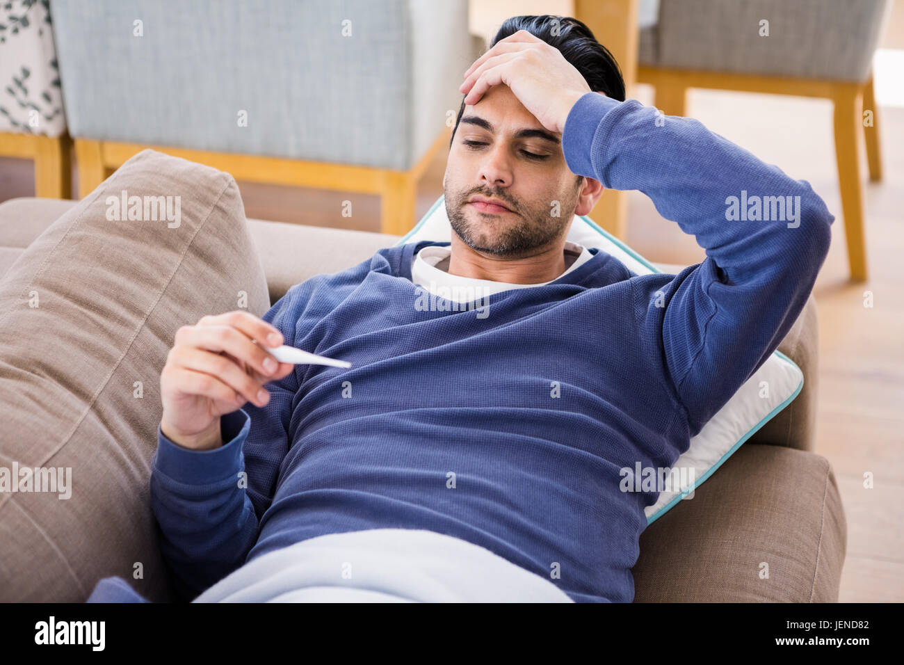 Sick man checking his temperature Stock Photo - Alamy