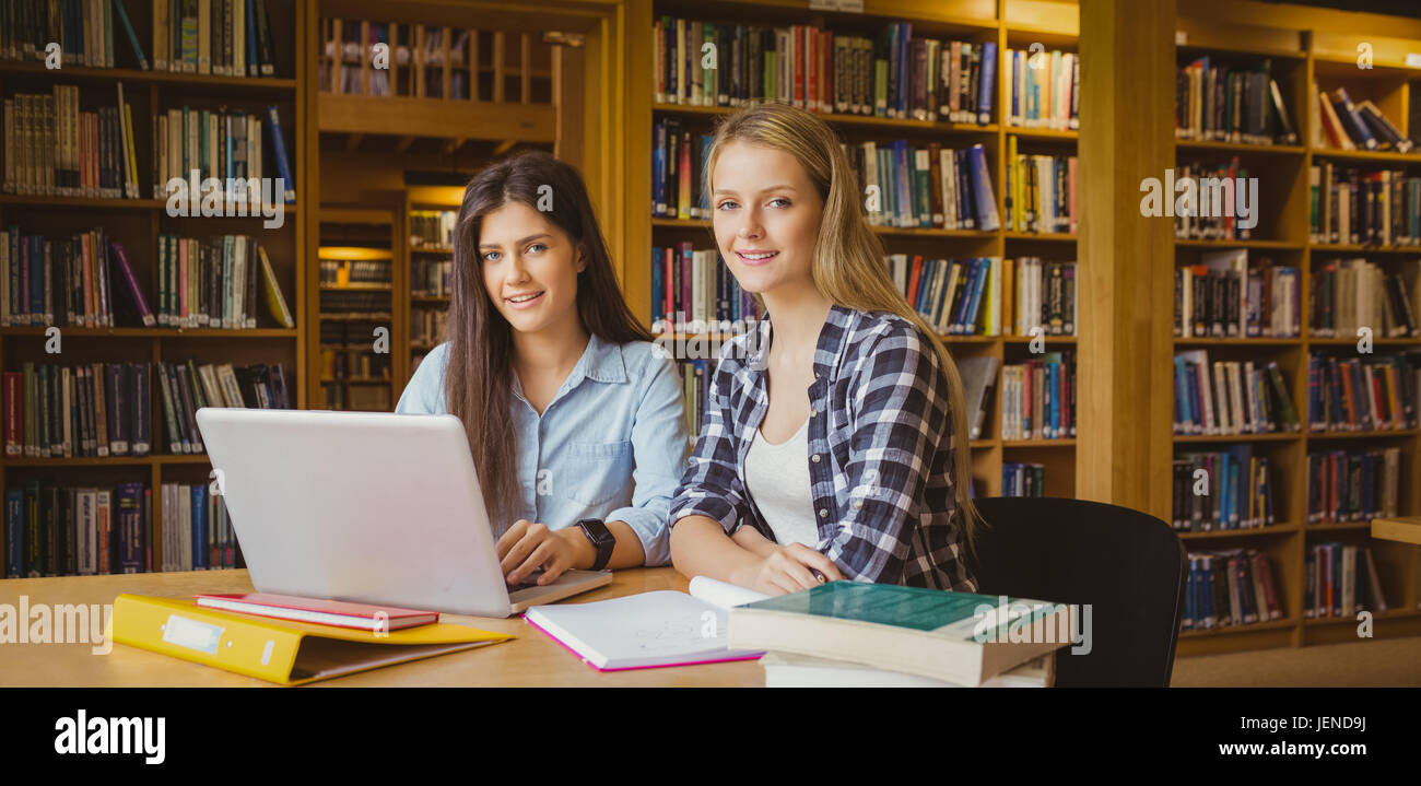 Smiling students using laptop Stock Photo - Alamy