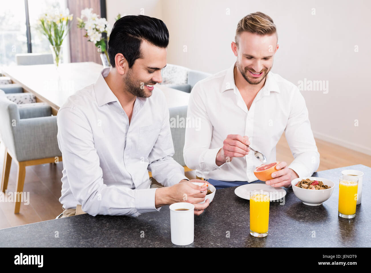 Smiling gay couple having breakfast Stock Photo - Alamy