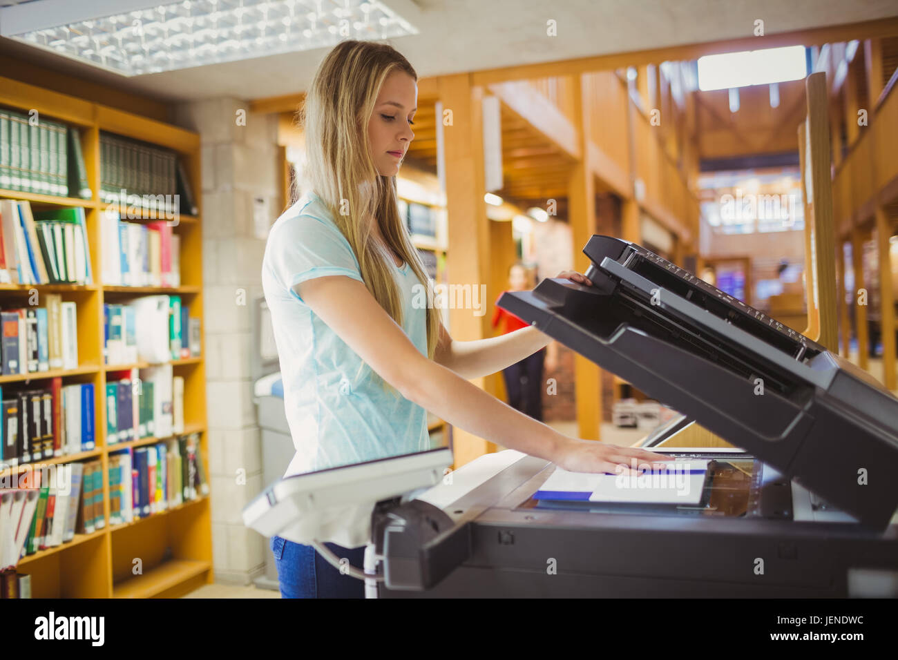 Smiling blonde student making a copy Stock Photo - Alamy