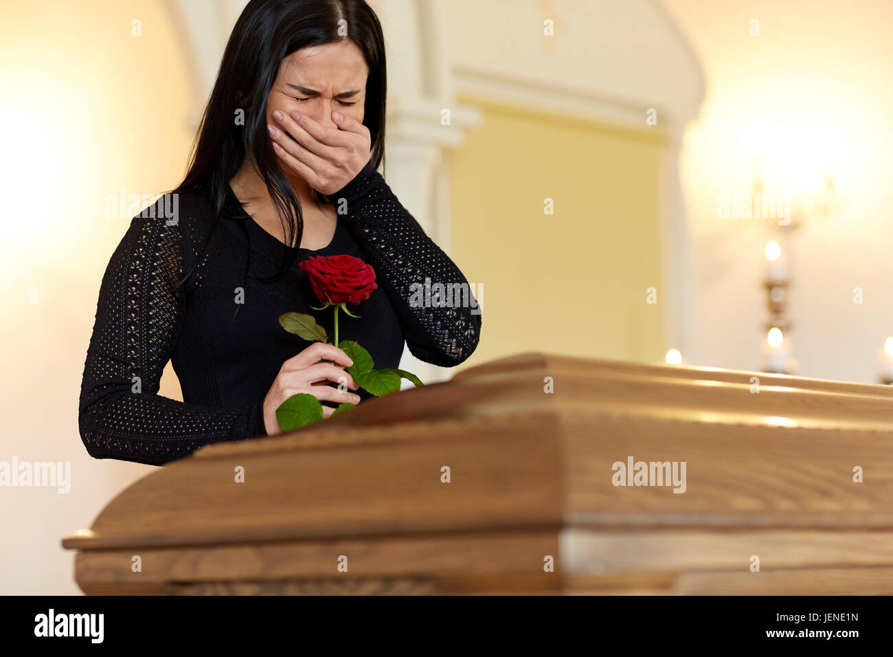 crying woman with red rose and coffin at funeral Stock Photo - Alamy
