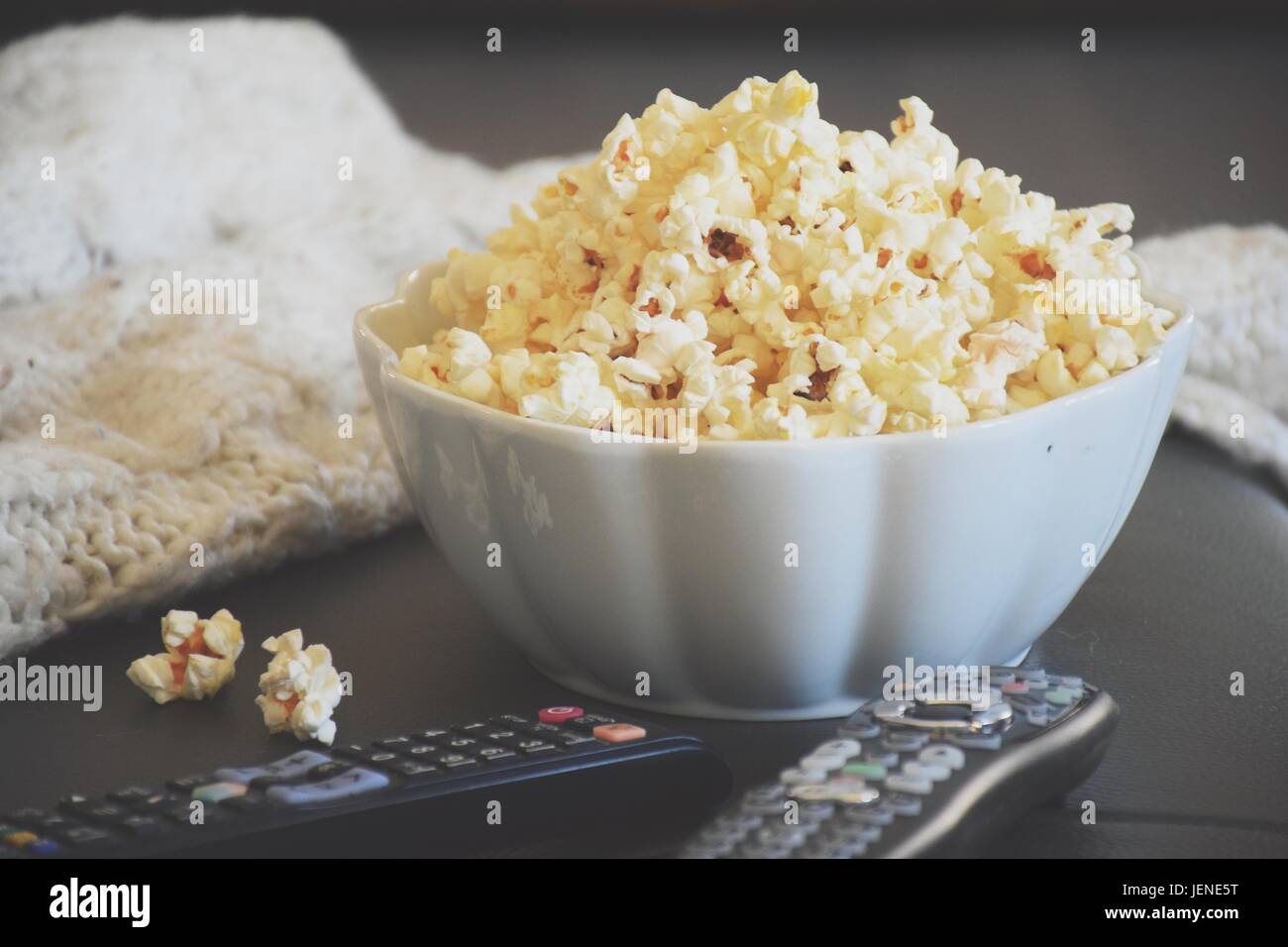 A bowl of popcorn with TV remote controls Stock Photo - Alamy