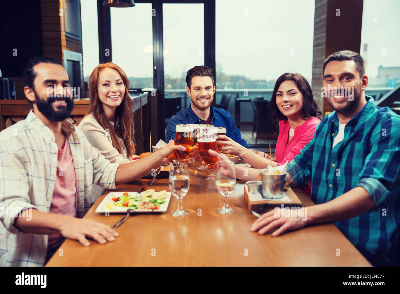friends dining and drinking beer at restaurant Stock Photo - Alamy