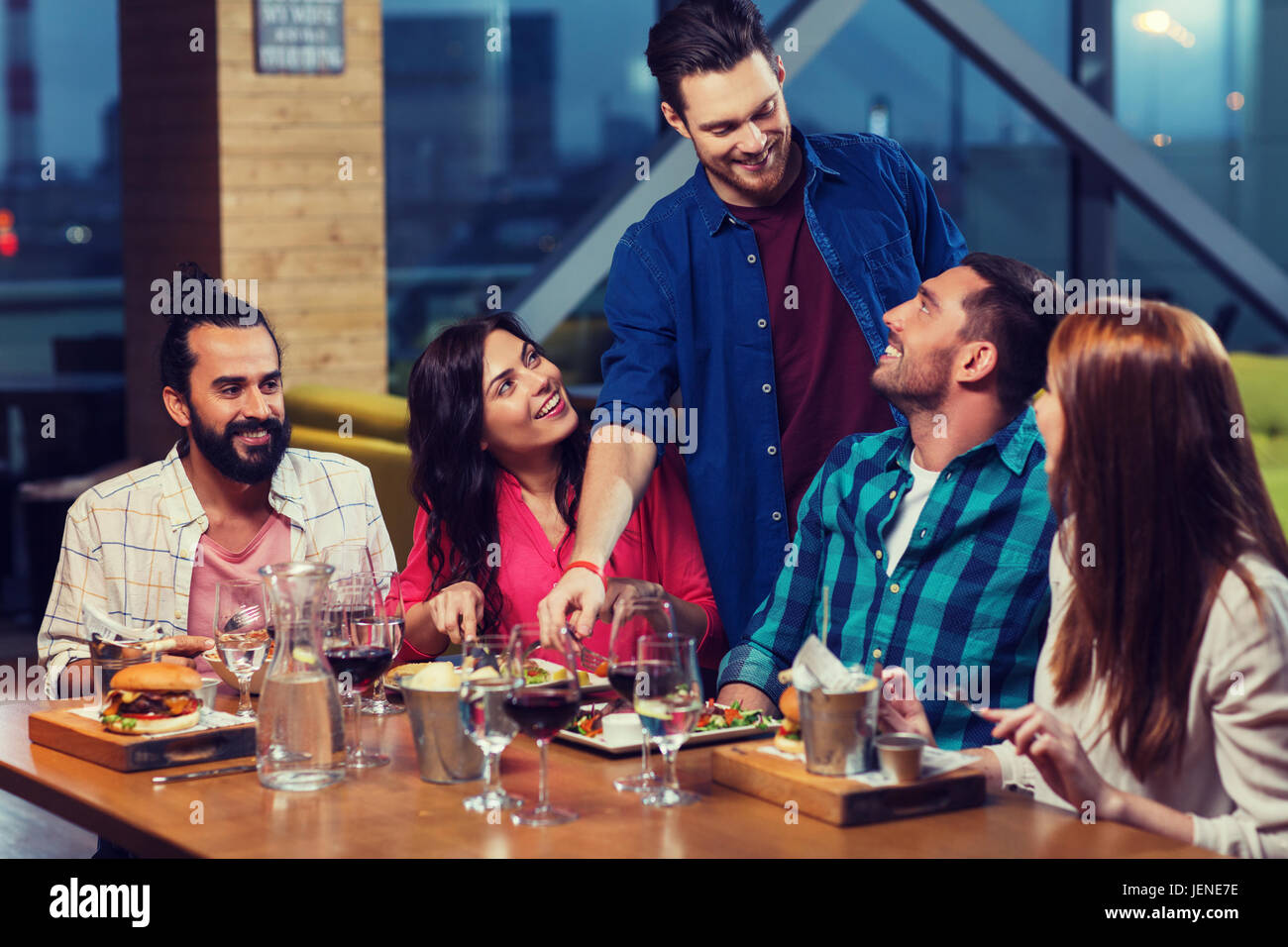 friends dining and drinking wine at restaurant Stock Photo - Alamy