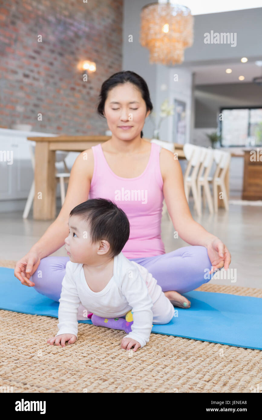 Calm mother meditating on mat at home Stock Photo - Alamy