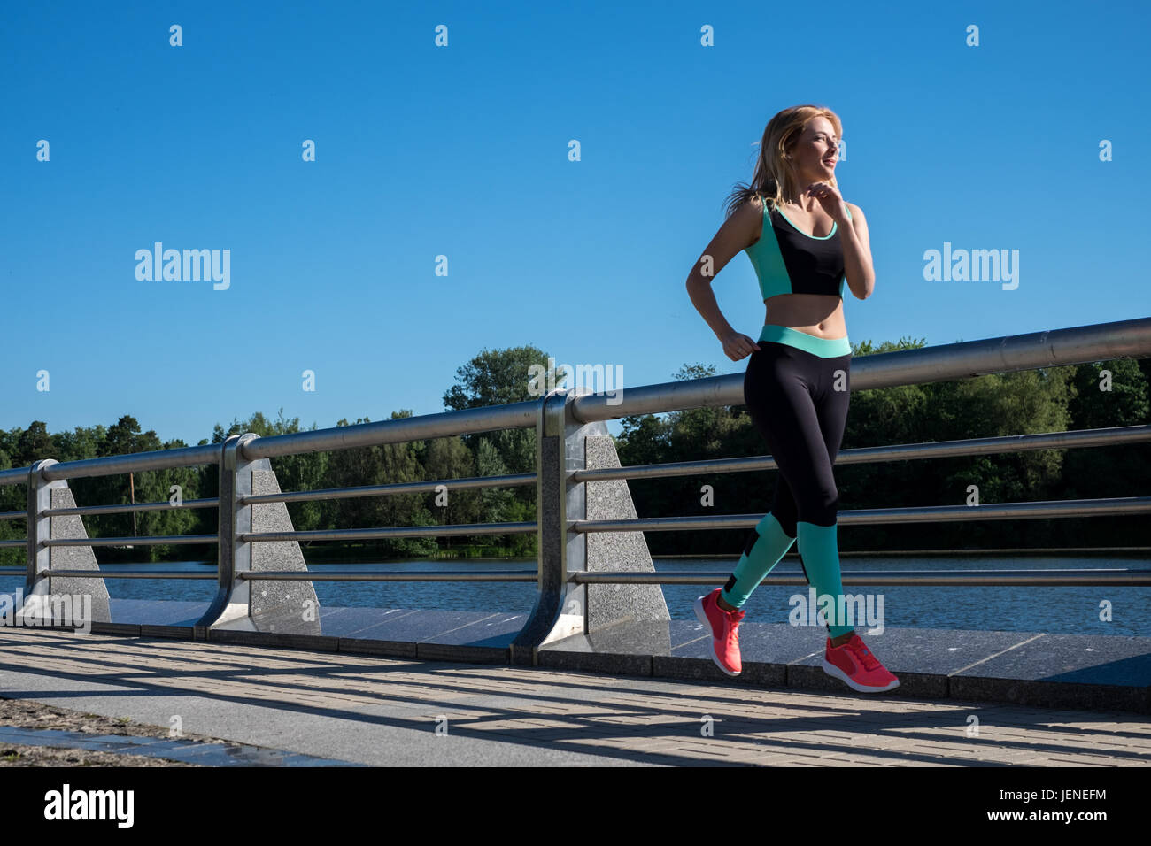 Woman running across a bridge Stock Photo - Alamy