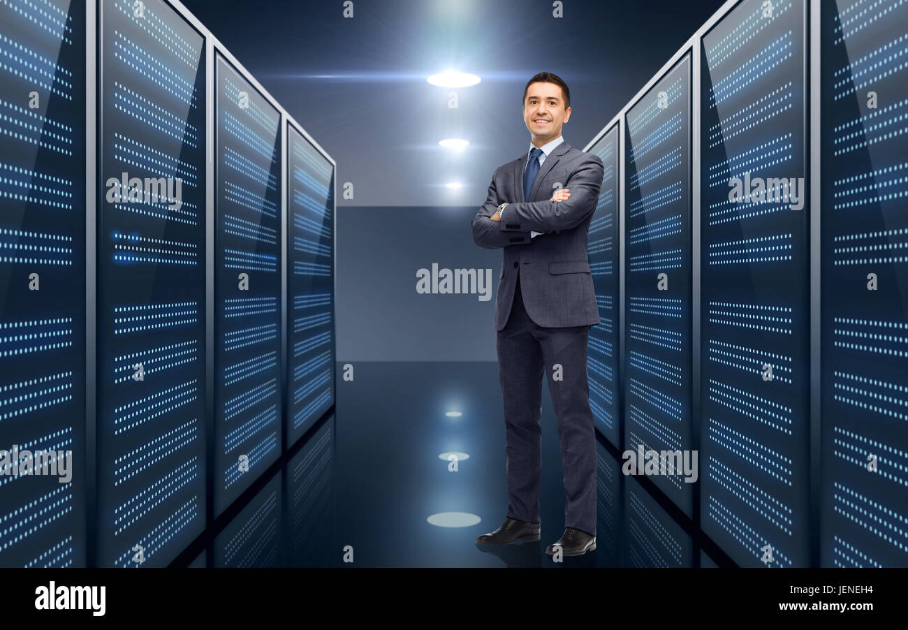 smiling businessman over server room background Stock Photo - Alamy