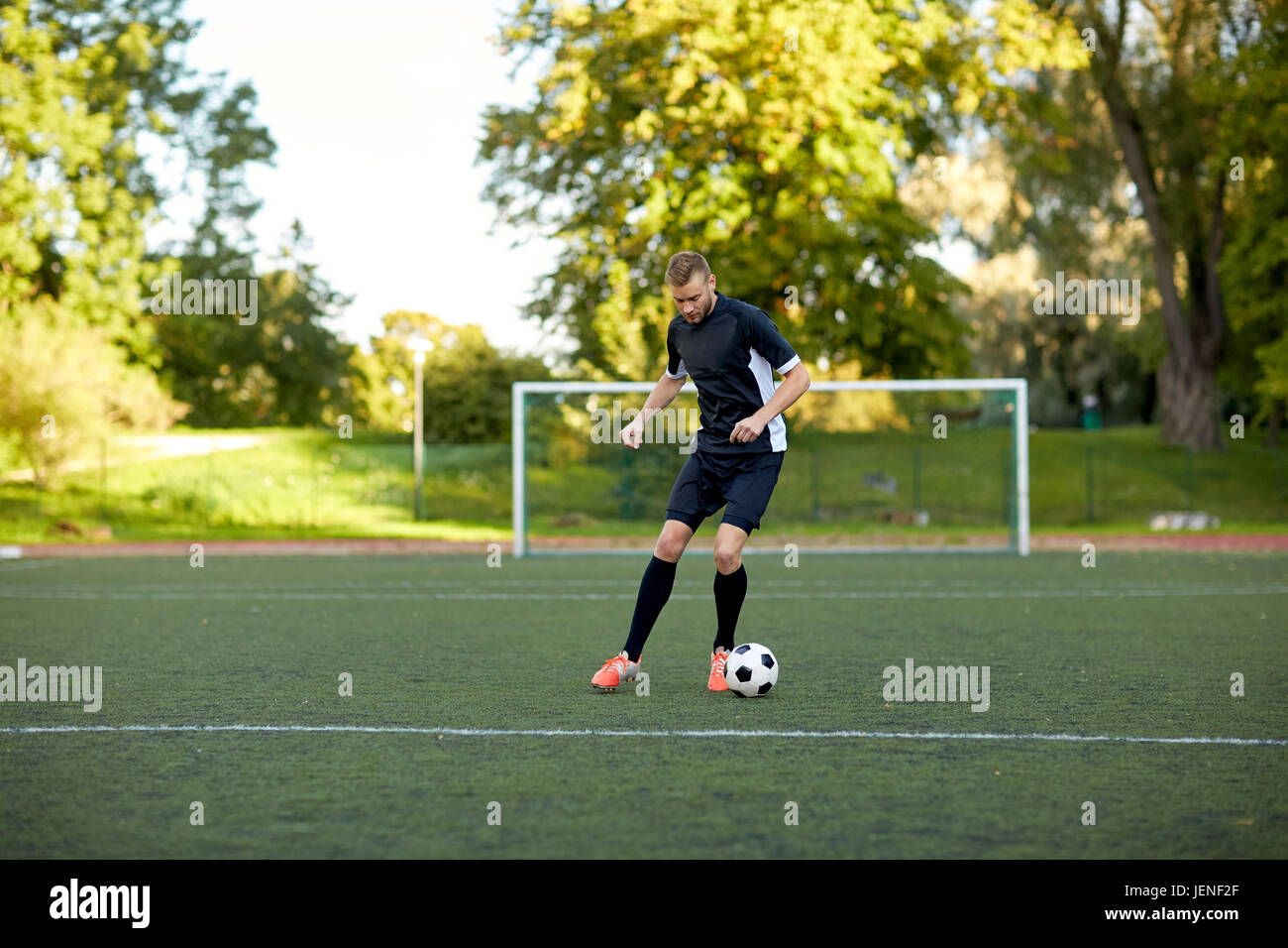 soccer player playing with ball on football field Stock Photo - Alamy