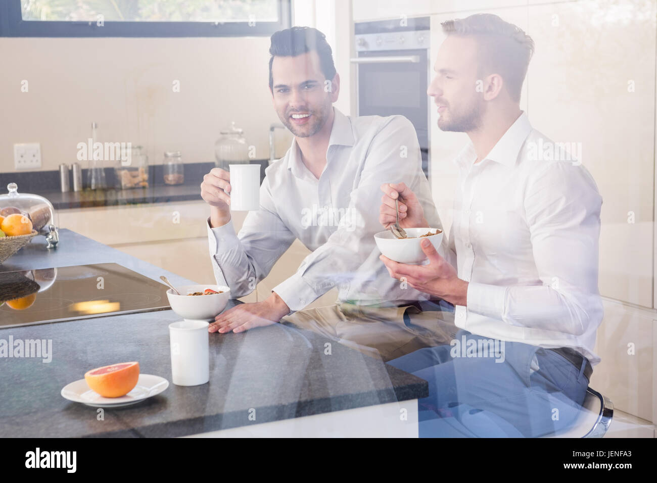 Smiling gay couple having breakfast Stock Photo - Alamy