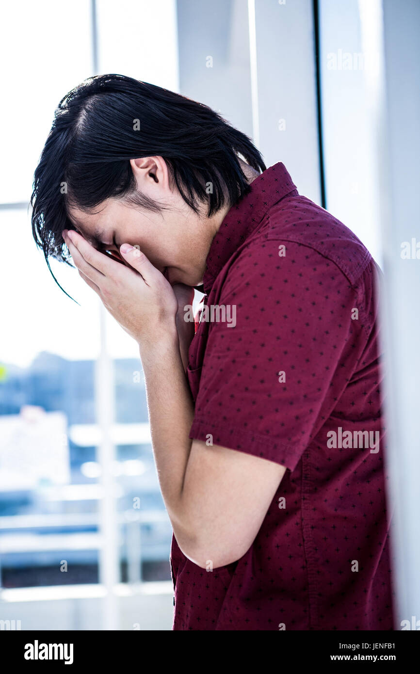 Worried creative businessman leaning on wall Stock Photo - Alamy
