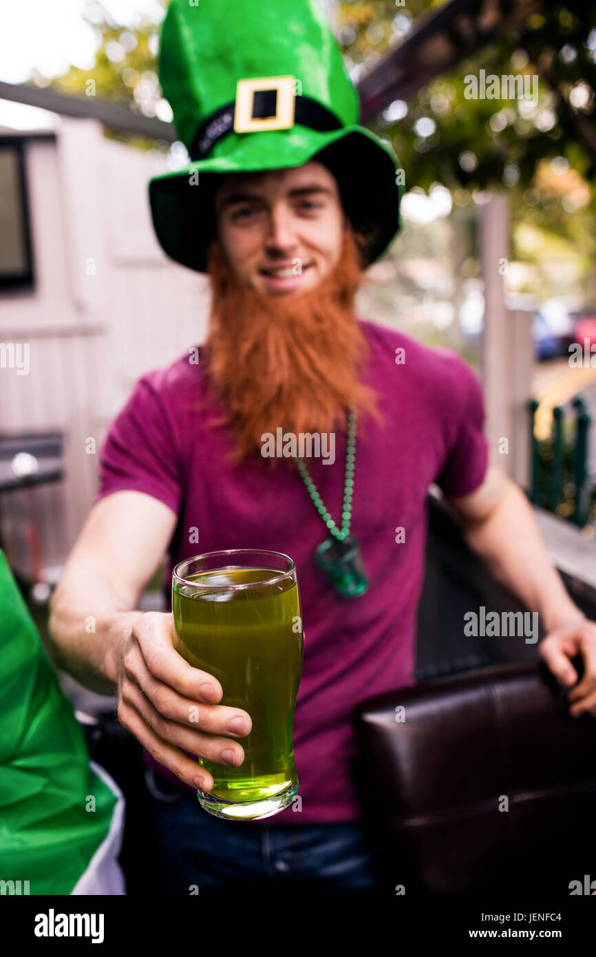 Disguised man holding a green pint Stock Photo - Alamy