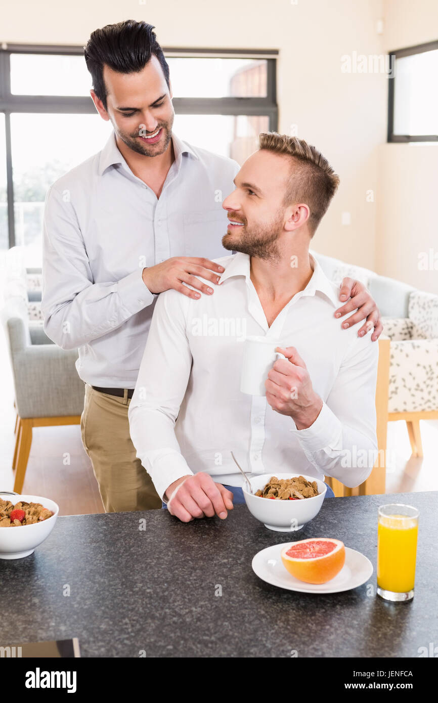 Smiling gay couple having breakfast Stock Photo - Alamy