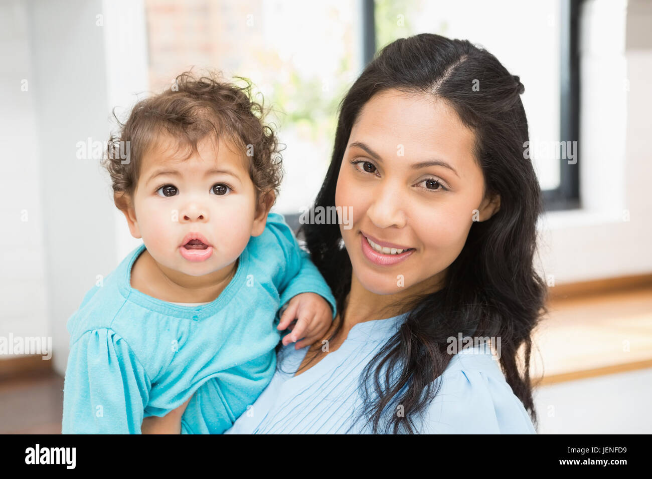 Smiling brunette holding her baby Stock Photo - Alamy