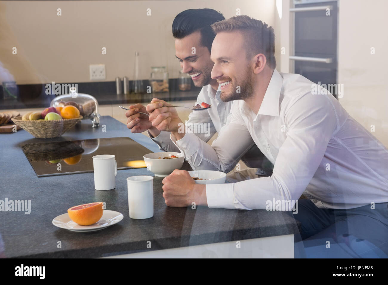 Smiling gay couple having breakfast Stock Photo - Alamy
