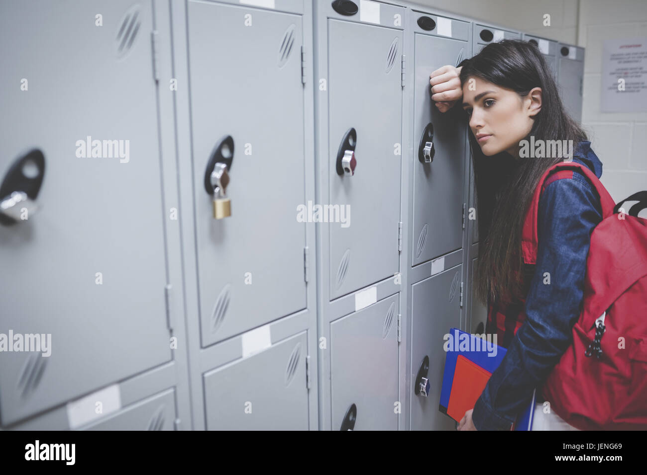 Sad student leaning on locker Stock Photo - Alamy
