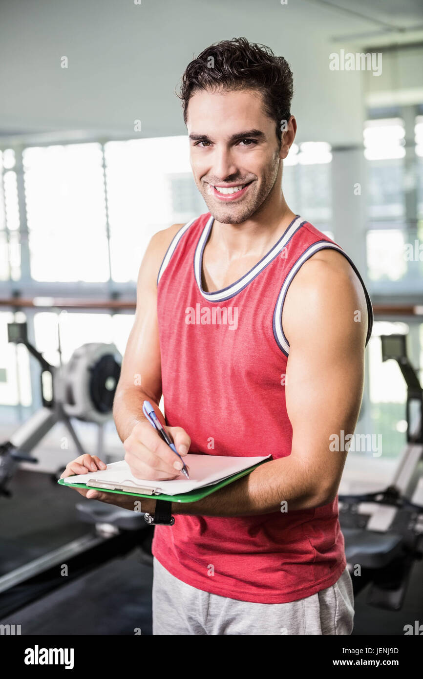 Smiling man writing on clipboard Stock Photo - Alamy