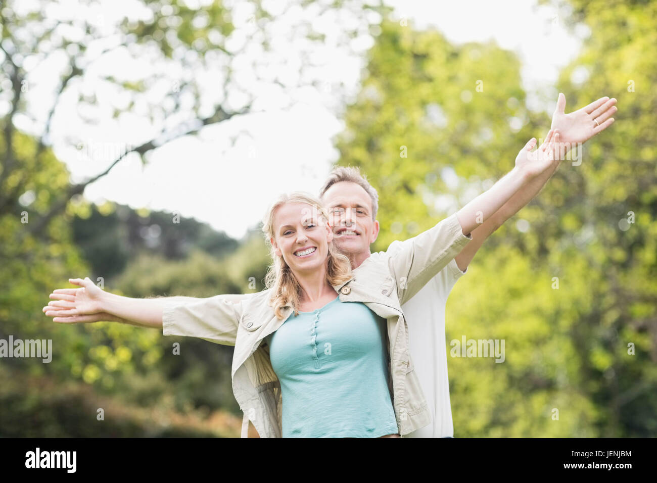 Cute couple raising arms Stock Photo - Alamy