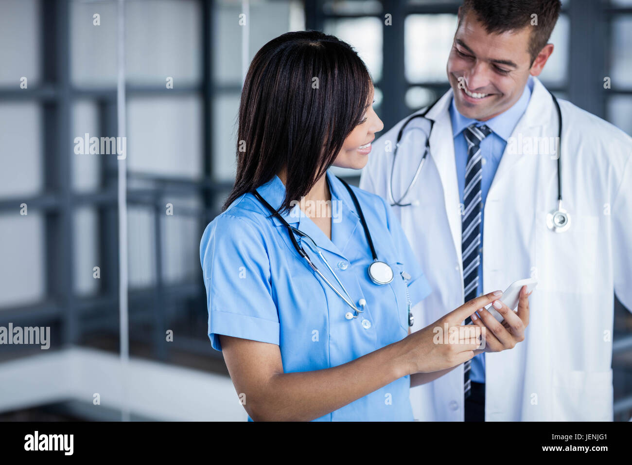 Medical team looking at phone together Stock Photo - Alamy