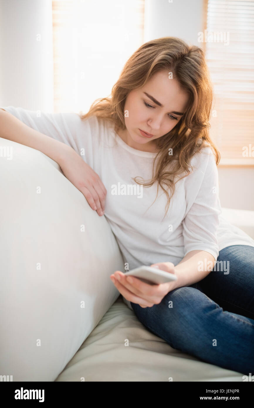 Sad woman watching her phone Stock Photo - Alamy