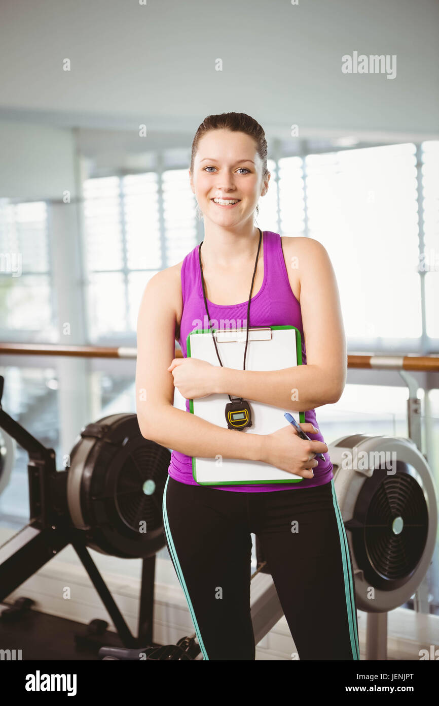 Smiling trainer holding clipboard Stock Photo - Alamy