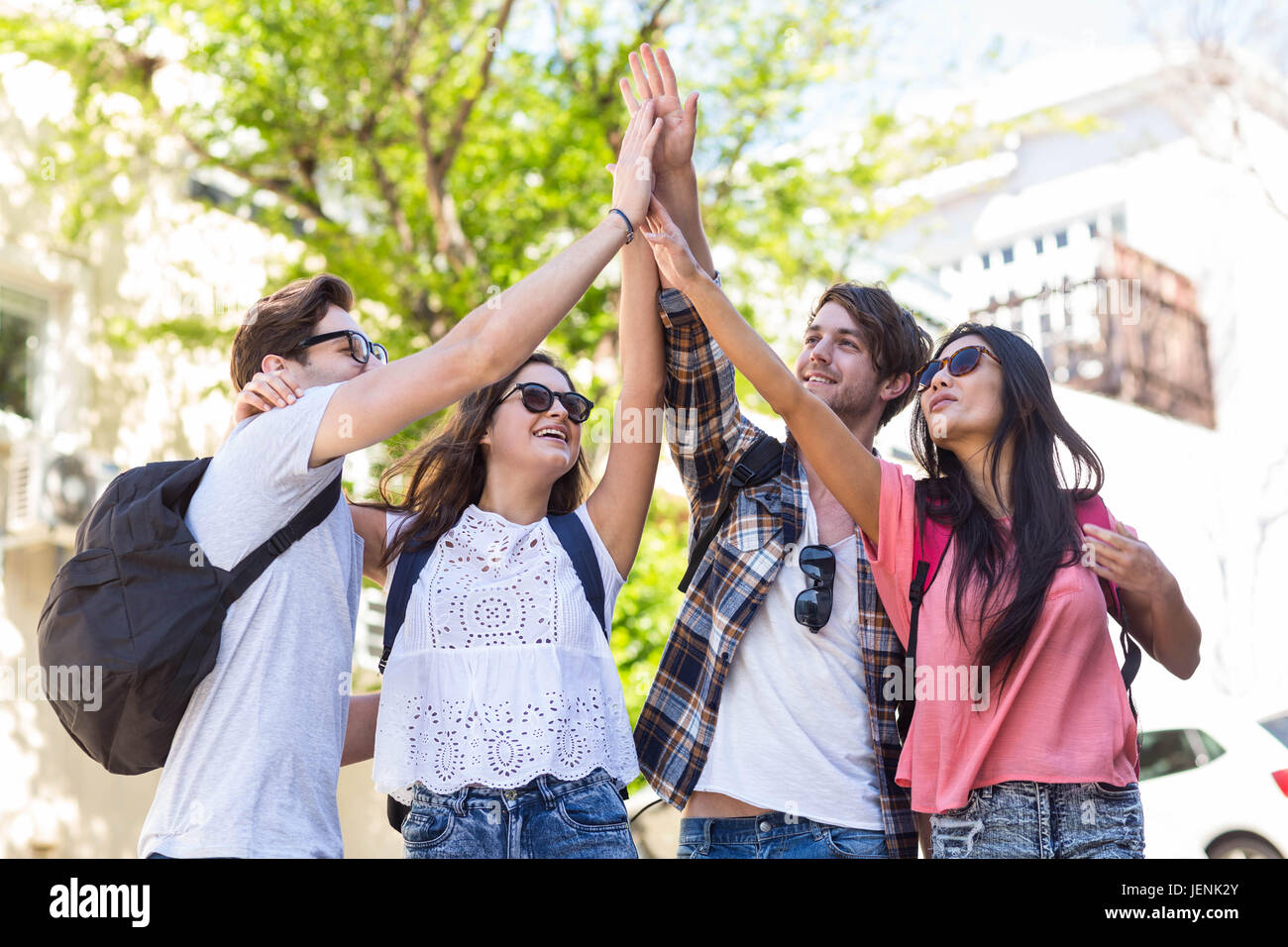 Hip friends doing high five Stock Photo - Alamy