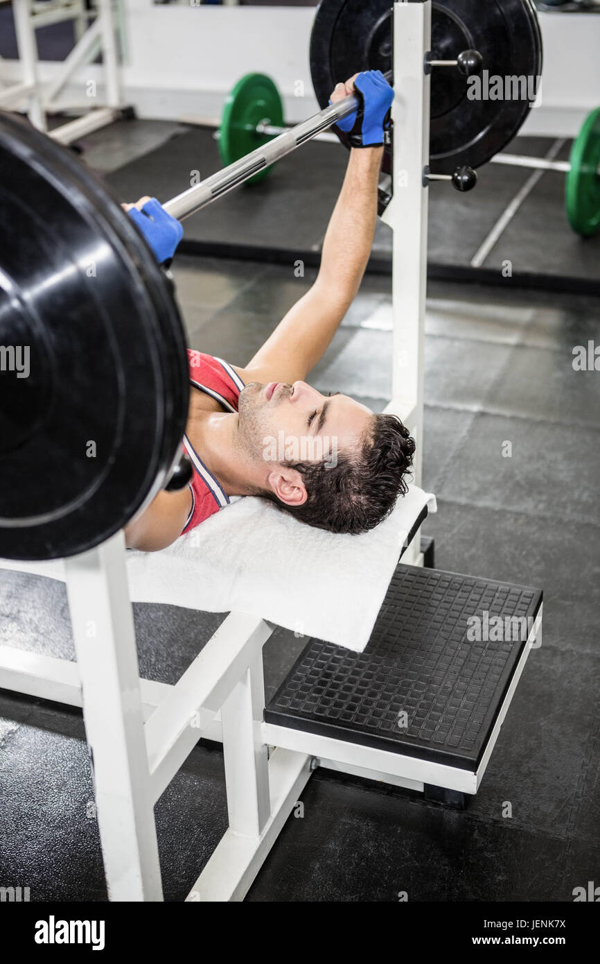Muscular man lifting barbell on bench Stock Photo - Alamy