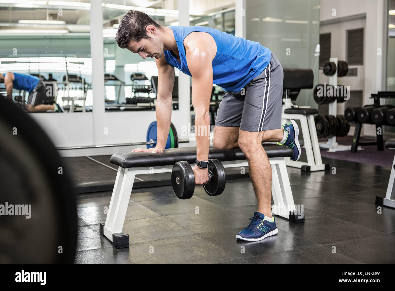 Handsome man lifting dumbbells on bench Stock Photo - Alamy