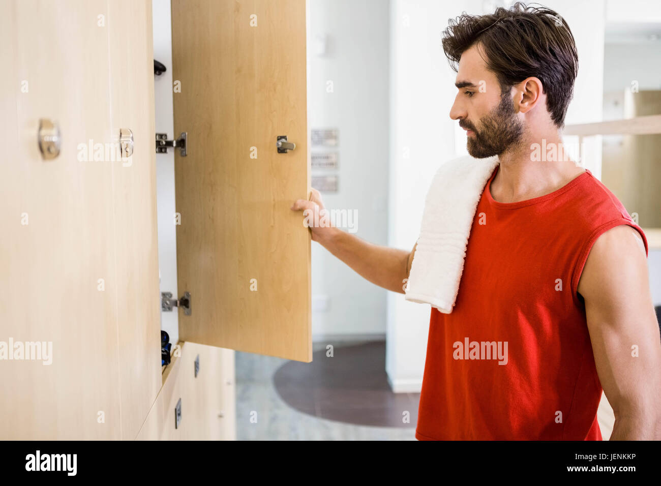 Smiling man opening locker Stock Photo - Alamy